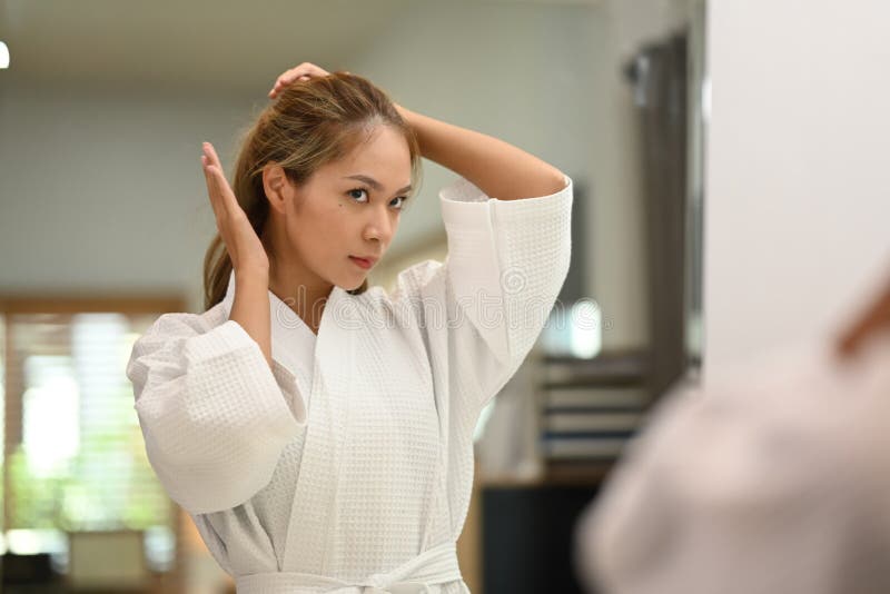 Reflecting in Mirror of Beautiful Millennial Woman in Bathrobe Standing ...