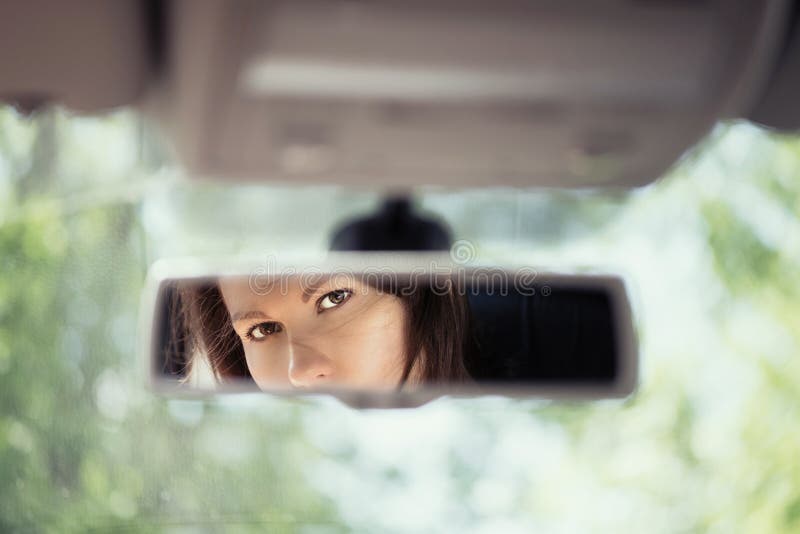 Reflection of a Beautiful Young Woman Face in the Car Rear View Mirror ... Reflection of a Beautiful Young Woman Face in the Car Rear View Mirror ...
