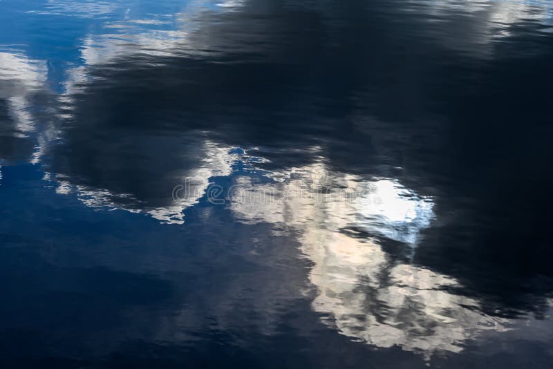 Reflection of Blue Sky and White and Gray Clouds on Smooth Water of ...