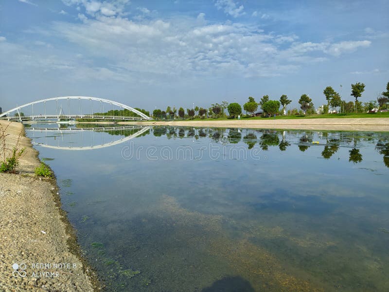 The Reflection of the Bridge and Nature on the Water Stock Photo ...