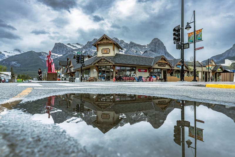 Reflection of a Building with Mountains in a Puddle in the Village ...