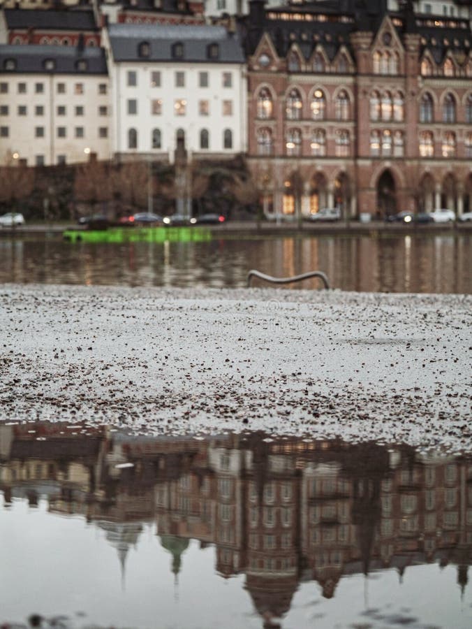 Reflection of Buildings in a Puddle Next To River Stock Image - Image ...