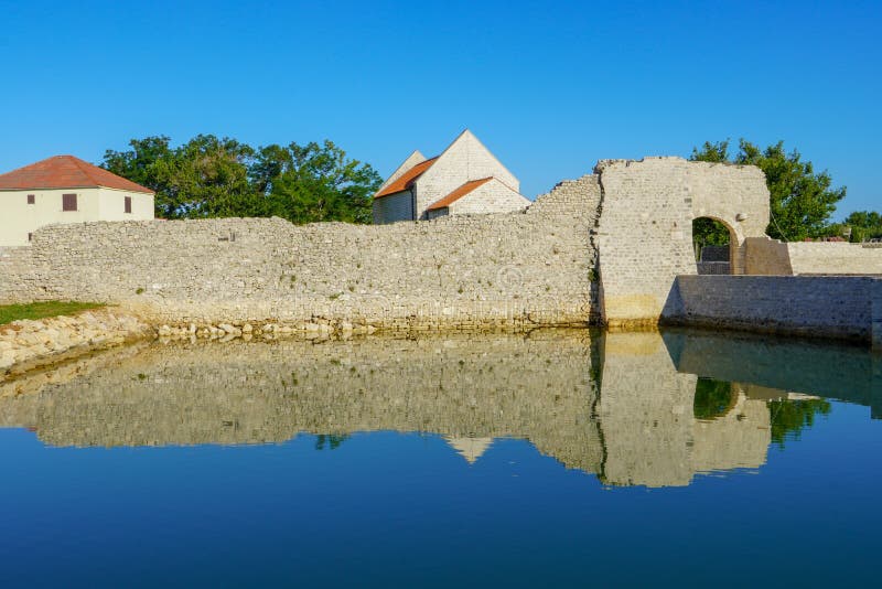 A Reflection in the Calm Blue Deep Water of Thick Stone Defensive Tower ...