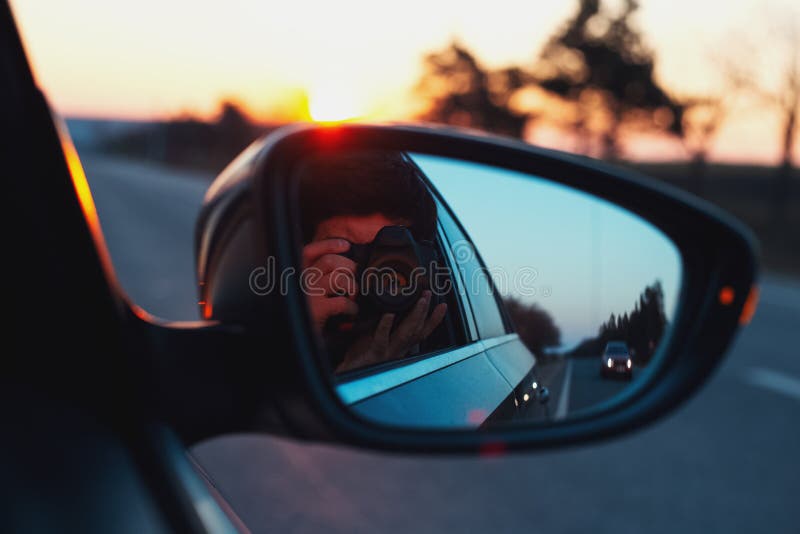 Reflection in Car Mirror of Young Guy Taking Photo of Sunset with ...