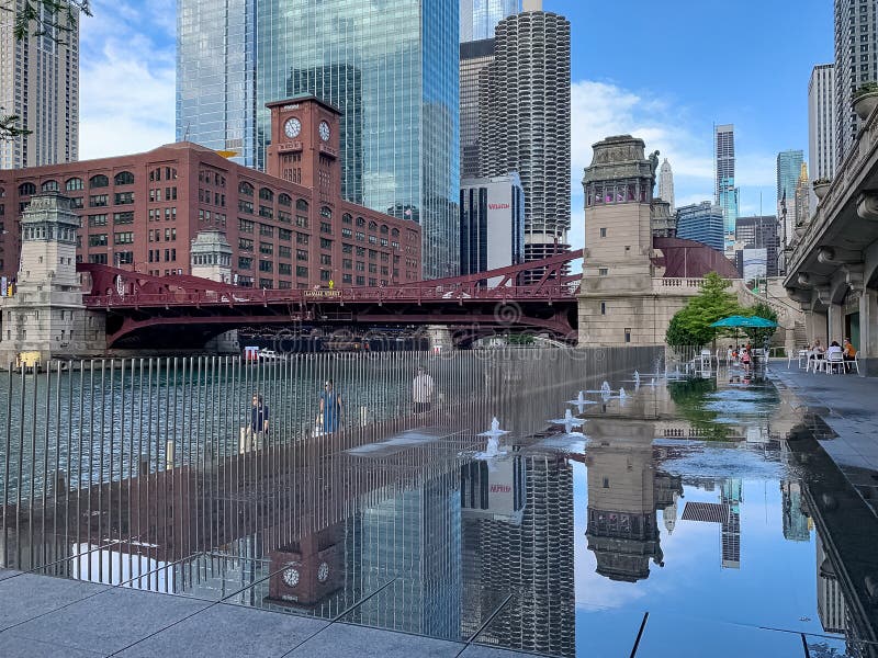 Reflection of Chicago Cityscape in Splash Pad Puddle while Tourists and ...