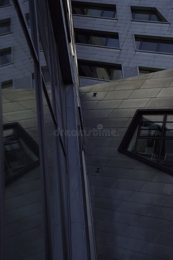 The Reflection of a Clock on a Building Across from it Stock Image ...