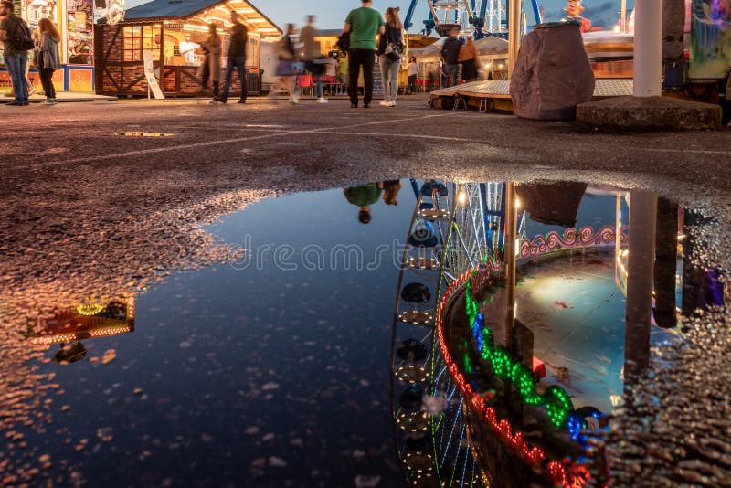 Reflection of Colourful Illuminated Motion of Carousel and Ferris Wheel ...