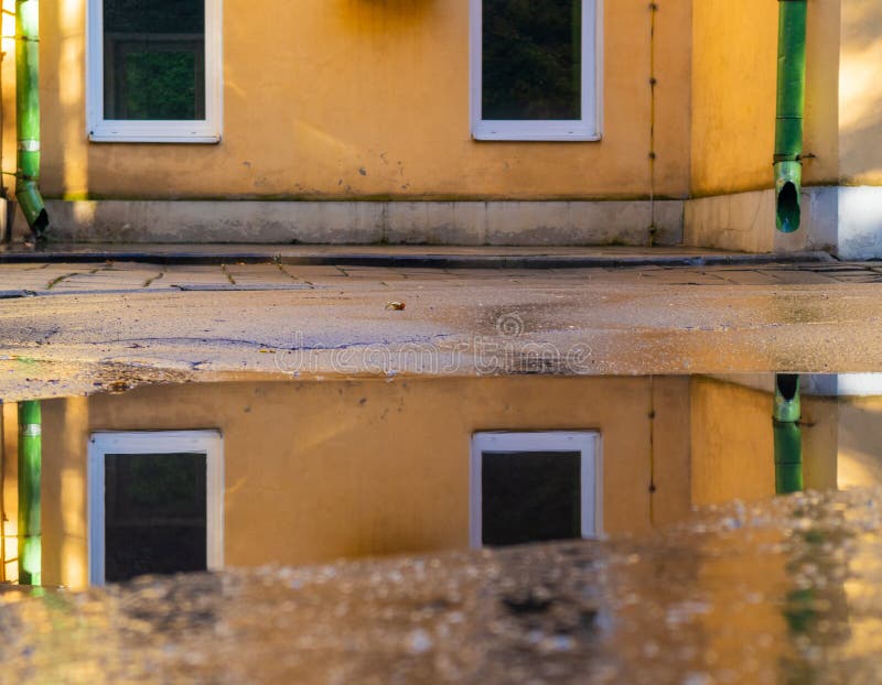 Reflection of Dark Windows of an Old House in a Puddle after Rain Stock ...