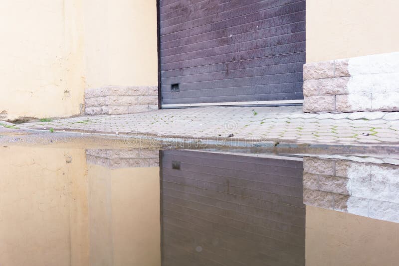 Reflection of a Garage Door in a Puddle of Water Stock Image - Image of ...