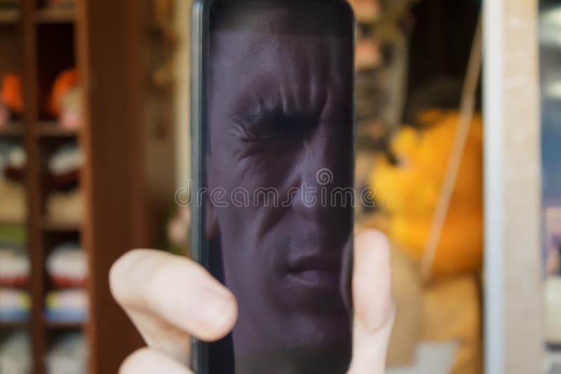 Reflection of Half the Face of a Guy on the Screen of a Smartphone ...