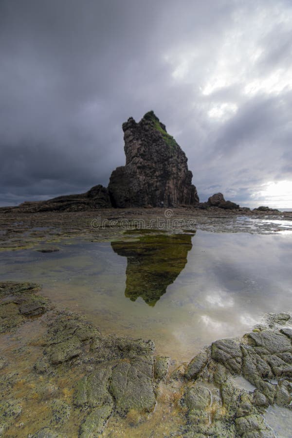 Reflection of a Massive Rock on a Puddle by the Beach Stock Photo ...