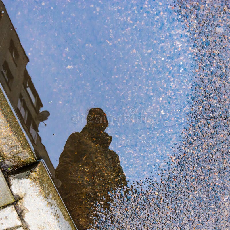 Reflection of Men Walking in Puddle on the Street. Stock Image - Image ...