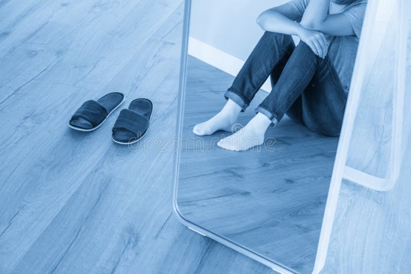 Reflection in Mirrow of a Sad Woman Sitting on a Floor Alone in Empty ...
