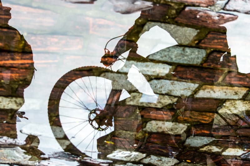 Reflection of Person and Bicycle in a Puddle of Rainwater in the River ...