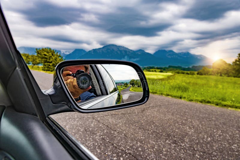 Reflection of a Photographer with a Camera in the Rear View Mirror of a ...
