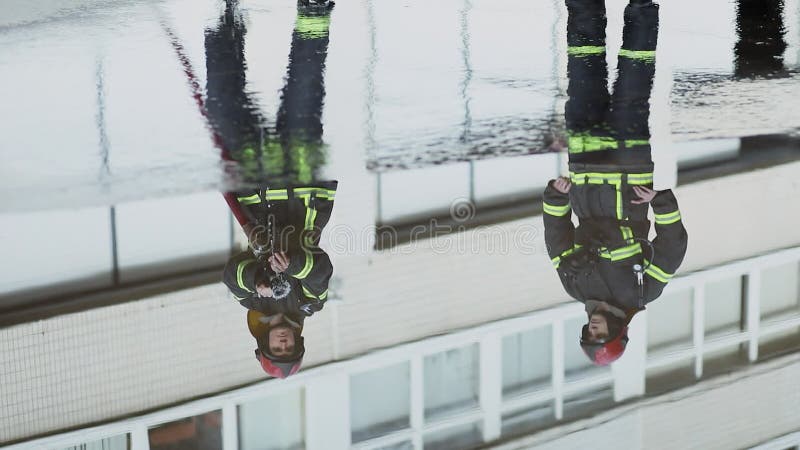 Reflection in Puddle of Two Firefighters with Stock Video - Video of ...