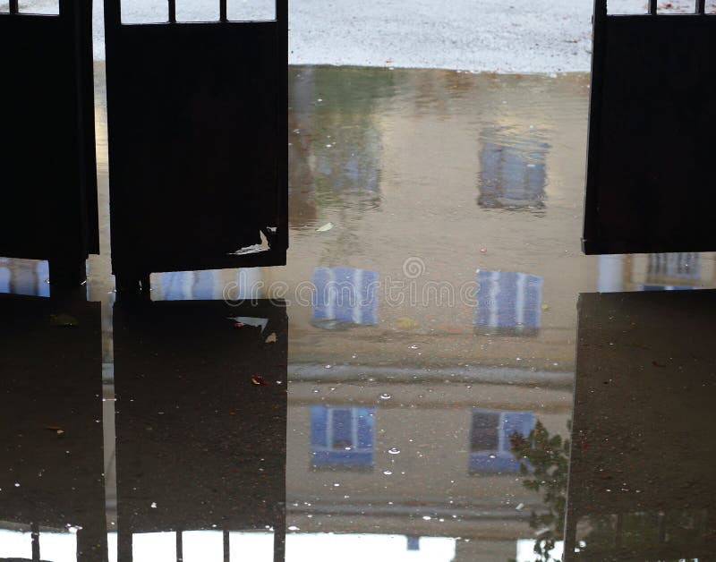 Reflection in a Puddle Under the Gate Stock Image - Image of rain, gate ...