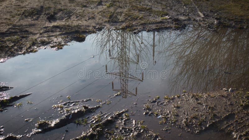 Reflection of Pylon in Muddy Puddle Stock Photo - Image of ecology ...