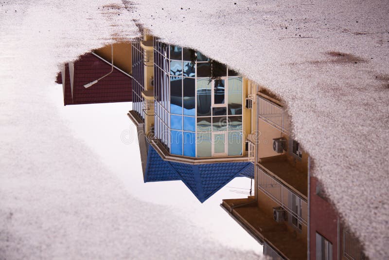 Reflection of a Residential Building in a Puddle on the Asphalt Stock ...