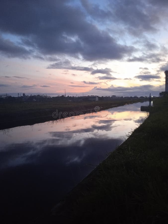 Reflection of a Rising Sun in a River Flowing through a Mountain Valley ...