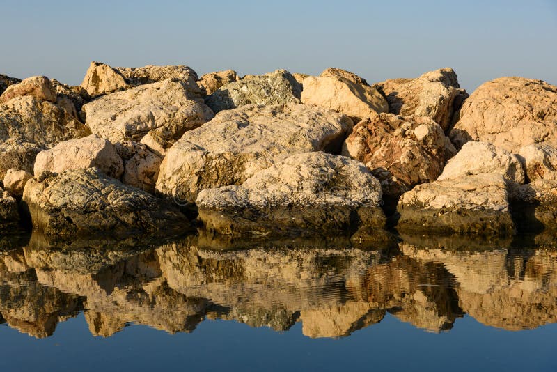 Reflection of Rocks on the Sea Stock Photo - Image of phenomenon, water ...