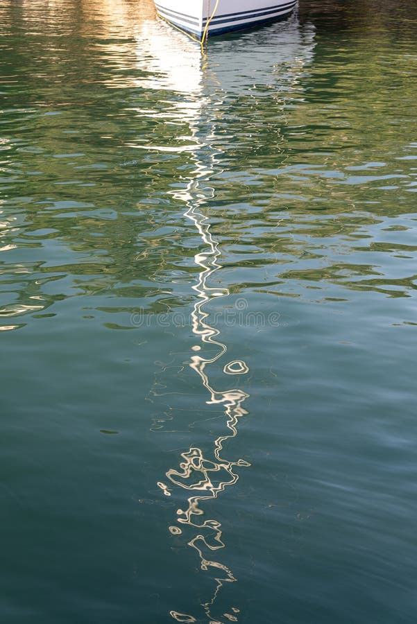 A Reflection of a Sailboat in the Small Ripples of the Sea. Abstract ...
