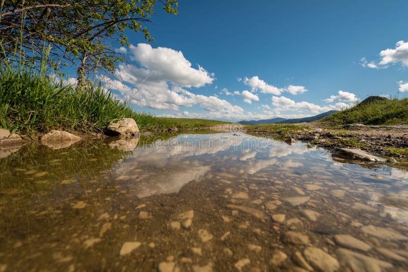 Reflection of Sky and Clouds in a Small Puddle in the Summer. Stock ...
