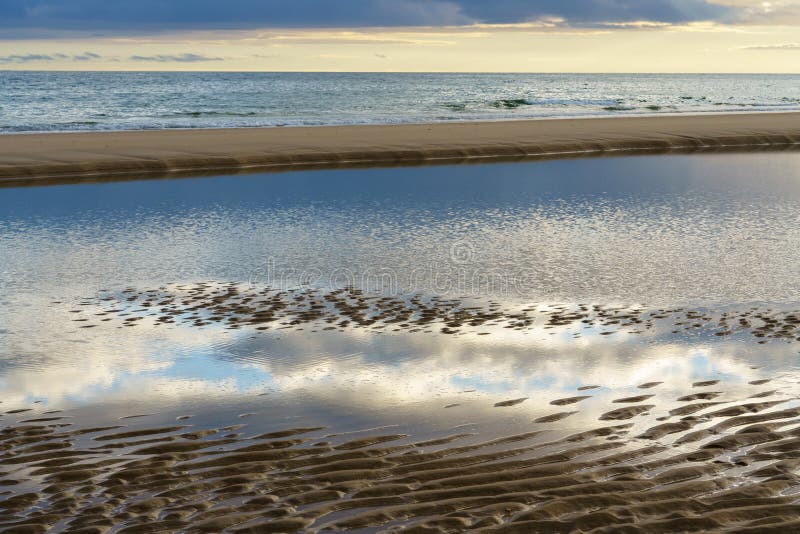 Reflection of the Sky on a Shallow Tidal Pool at a Sandy Beach Stock ...