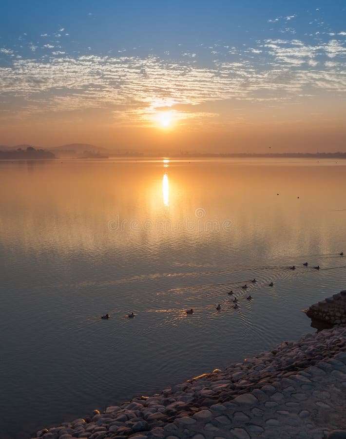 Sunset at Distant Edge of Lake Stock Image - Image of lake, covered ...