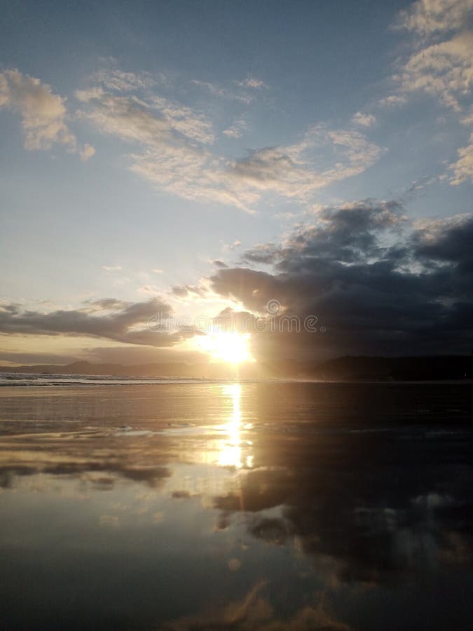 The Reflection of the Sunset on the Beach in a Beautiful, Cloudy ...