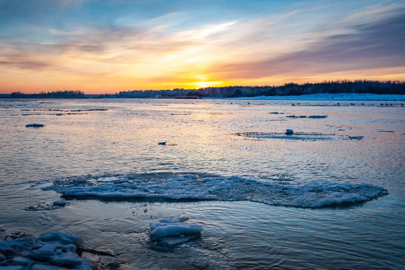 Reflection of the Sunset in the Icy Lielupe River. Cracked Ice on the ...