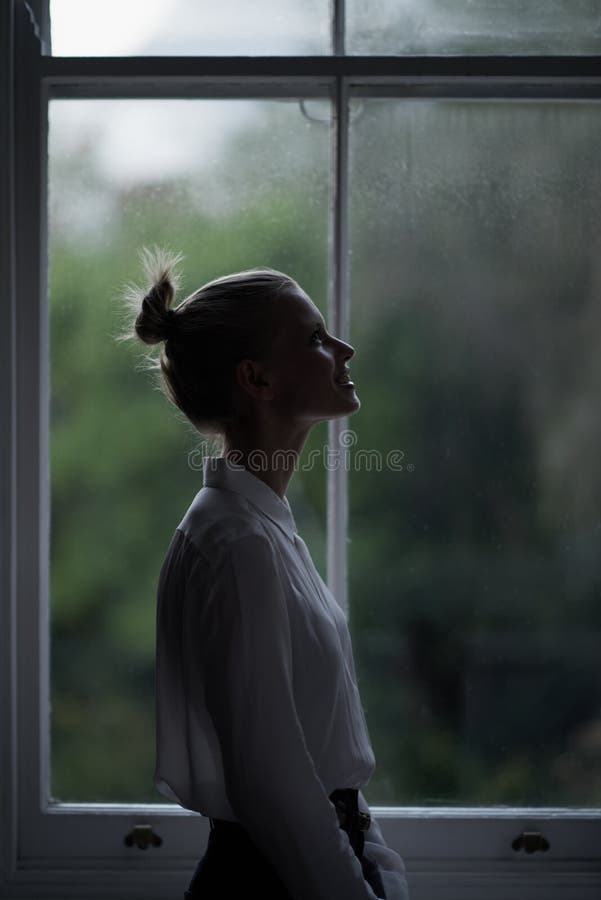 Reflection by the Window. a Beautiful Young Woman Standing by a Window ...