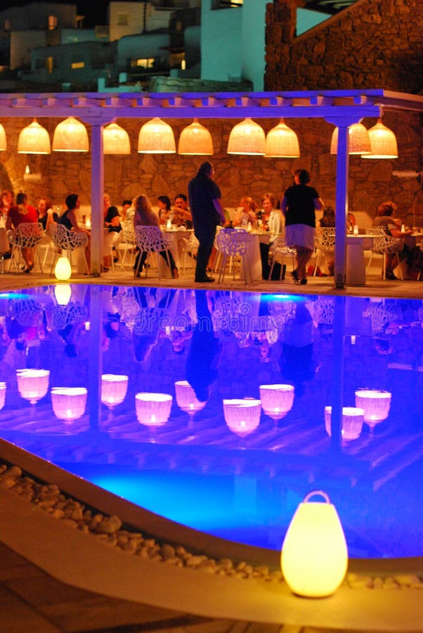 Reflections of Light in a Pool in Mykonos with Restaurant and Diners ...