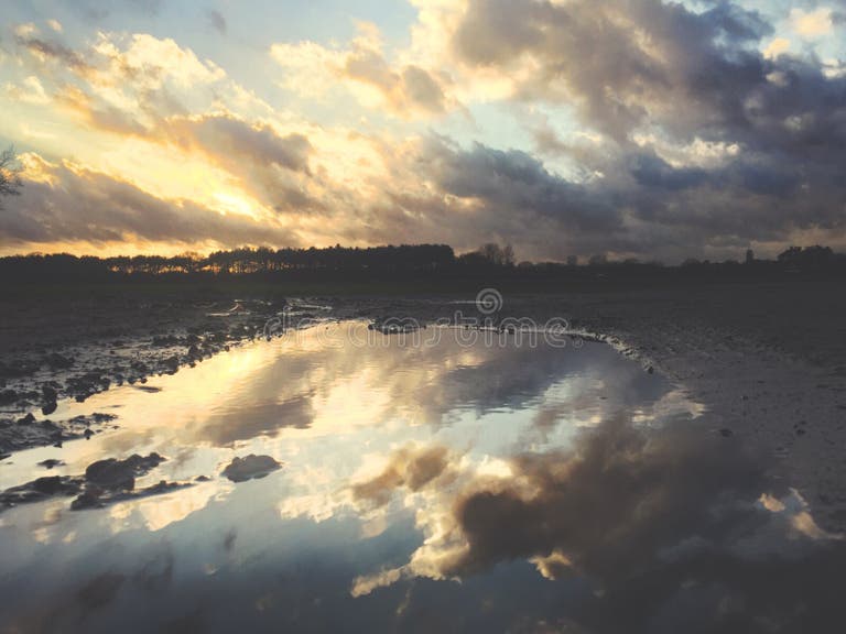 Reflections in a Puddle of a Beautiful Dramatic Sunset Over a Field ...