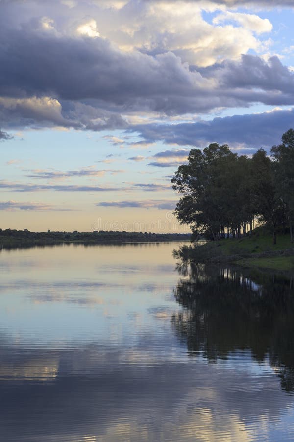 Reflections of Trees Blue Sky, and Clouds in Water with Vertical Waves ...
