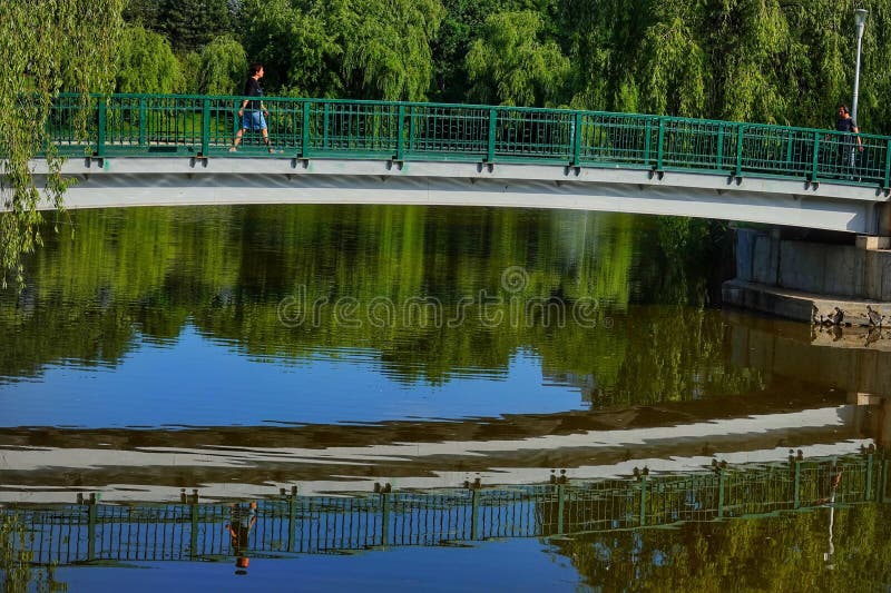 Reflections in the Water of Passers-by on the Bridge Stock Photo ...