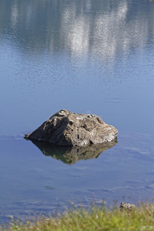 Reflections on the Waters of a Mountain Lake Over a Rock Stock Photo ...
