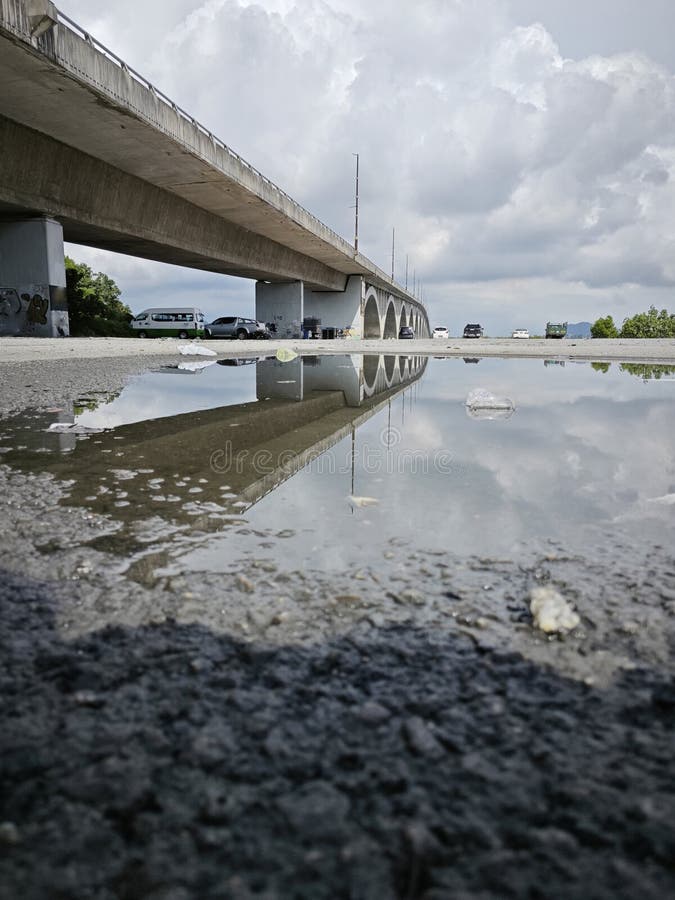 Reflective Pool of Water on the Asphalt Street Beneath the Bridge ...