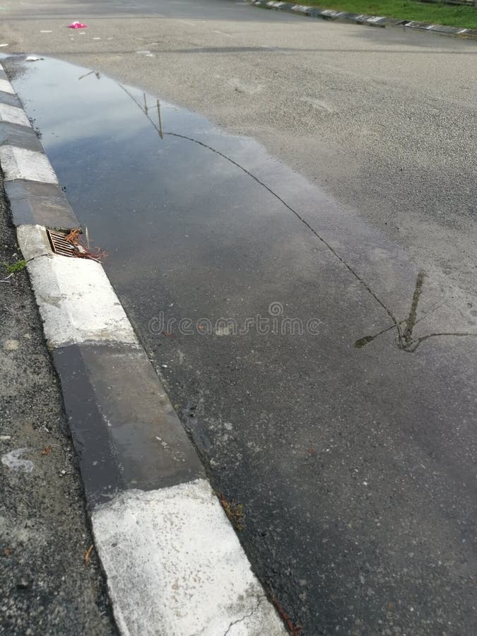 Reflective Puddle with Stagnant Water on the Roadside after the Rain ...