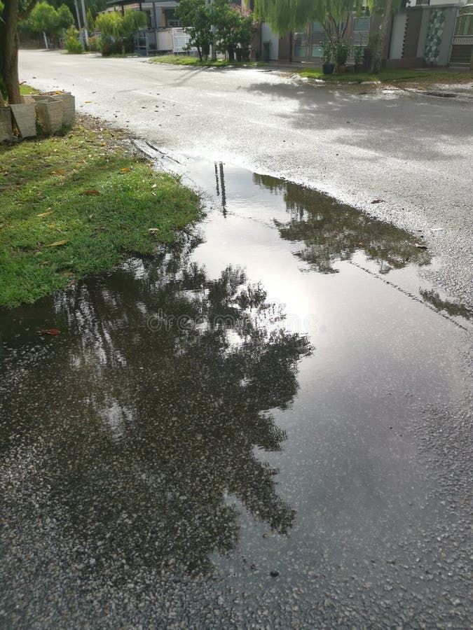 Reflective Puddle with Stagnant Water on the Roadside after the Rain ...