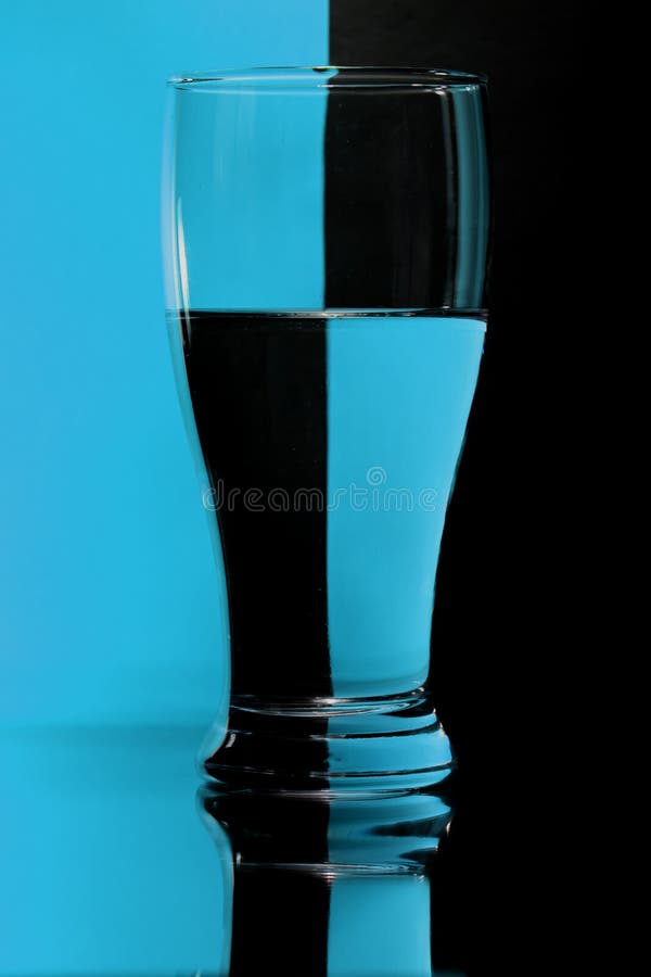 Refraction of Light by a Glass on a Blue and Black Squared Background ...