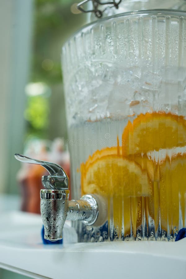 Refreshing Cool Water with Orange Slice at the Bar in Jars with Tap ...