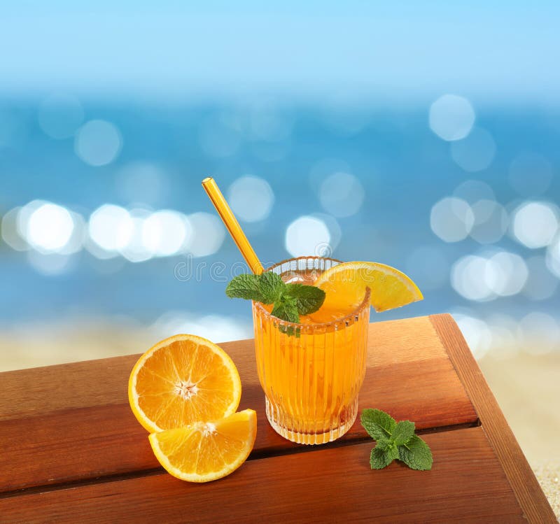 Refreshing Drink with Straw and Fresh Orange on Wooden Table at Beach ...