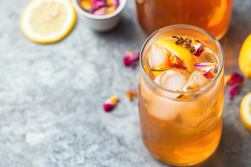 Refreshing Iced Tea with Citrus and Floral Garnish in Glass on Rustic ...