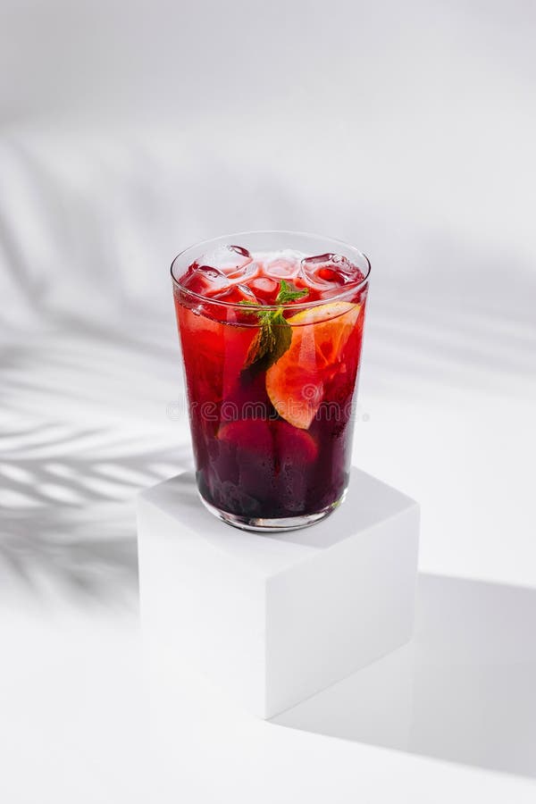 Refreshing Red Fruit Cocktail Standing on White Cube with Palm Leaf ...