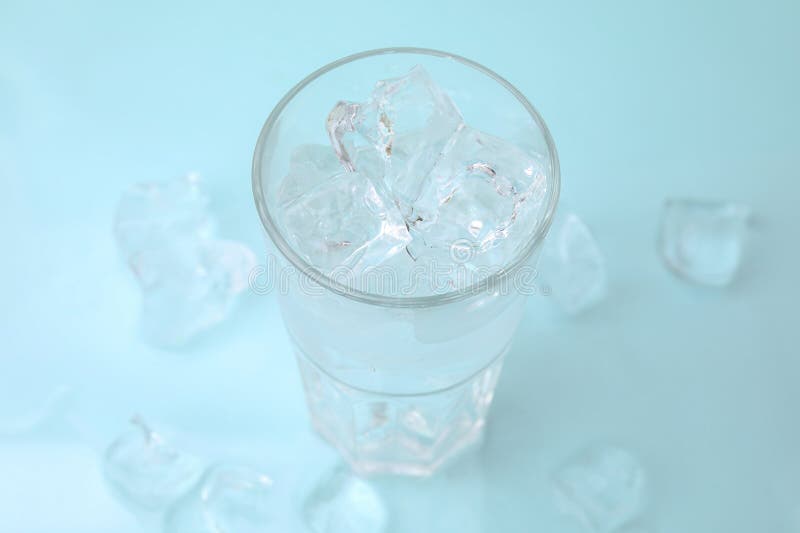 Refreshing Water in Glass with Ice Cubes on Light Blue Background ...