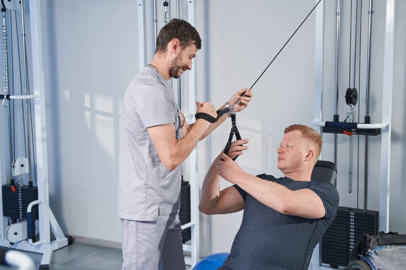 Rehab Therapy of Man with Disability Pull Straps on Stretching Machine ...