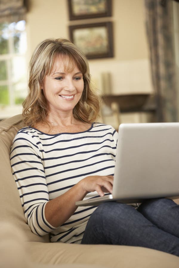 Mutter Mit Der Jugendlichen Tochter, Die Auf Sofa at Home Using Laptop ...