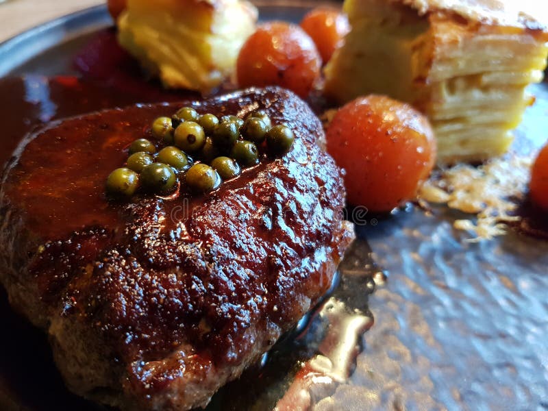 Reindeer Steak on Cast Iron Plate with Cheese Potatoes and Cherry ...
