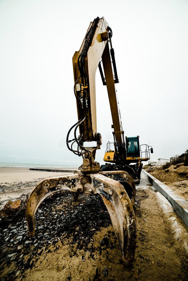 Crane Equipped with a Grapple Unloading the Large Rocks Stored in a ...